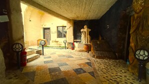 Quarto com piso estampado, uma estátua e vista para o exterior.