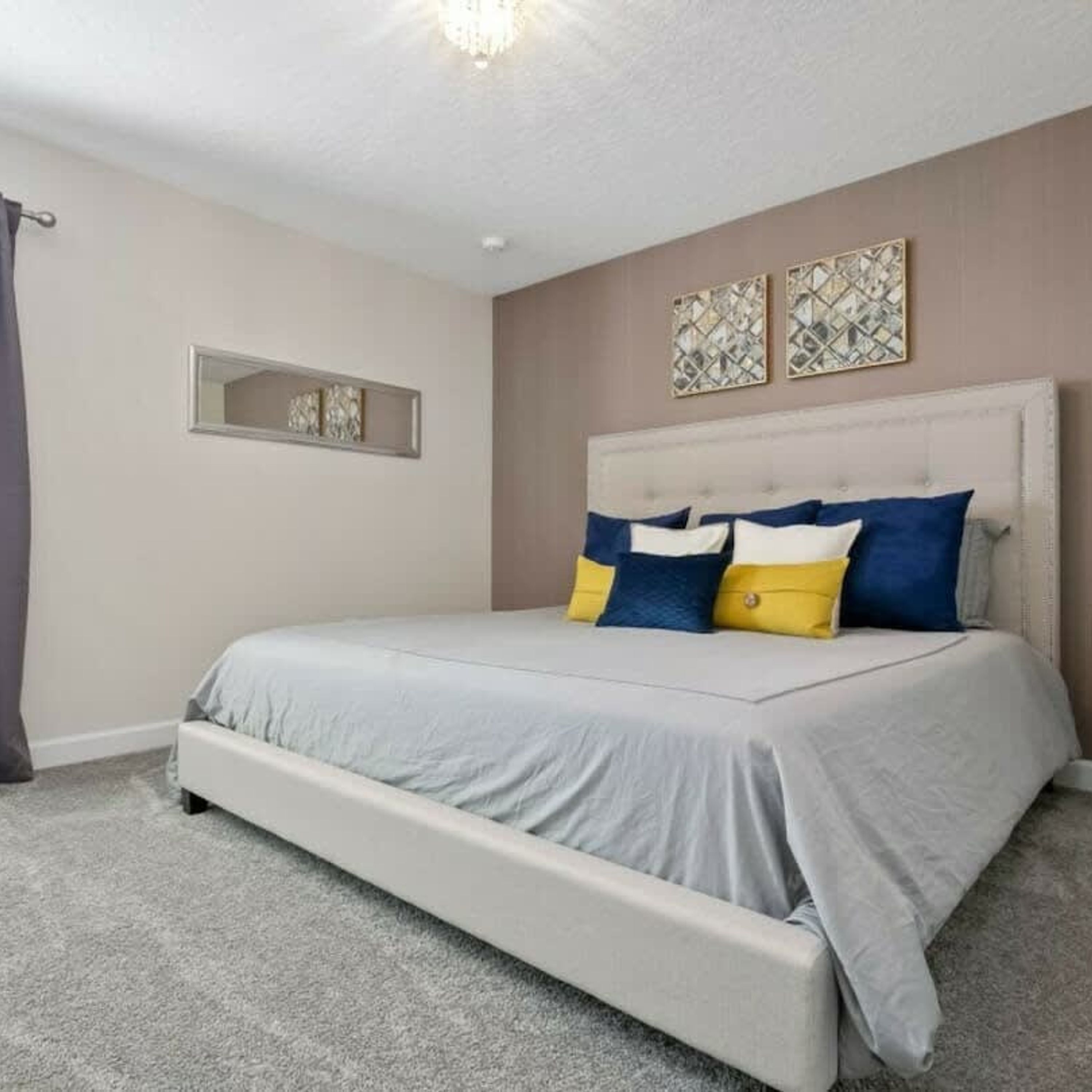 Quarto com cama, cabeceira e duas obras de arte penduradas na parede.