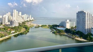 Um hotel alto com vista para um rio e o horizonte da cidade.
