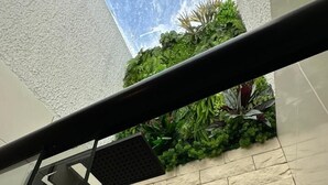 Uma escadaria com parede de pedra e vista para o verde.