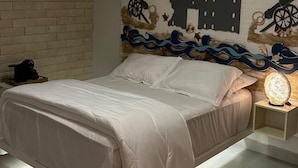 Quarto com luminária pendente, cama, mesa de cabeceira, prateleira na parede e estátua de Buda.