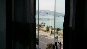 Vista pela janela, com uma rua e um corpo d'água ao fundo.