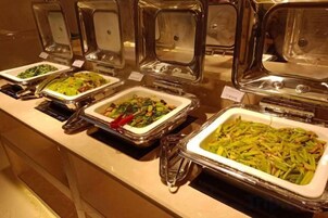 Buffet com diversas estações de serviço de alimentos.