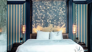 Quarto de hotel moderno com uma cama grande, piso de mármore e um design de teto único.