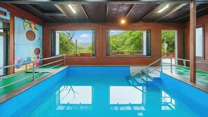 Piscina interior com vista para o verde lá fora.