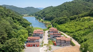 Uma área residencial com várias casas, uma estrada e um rio.