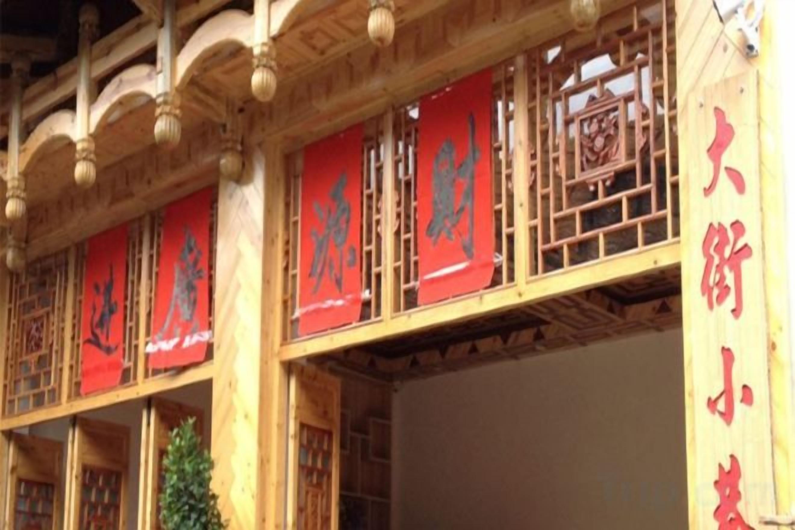 Um edifício de madeira tradicional com faixas vermelhas e caracteres chineses.