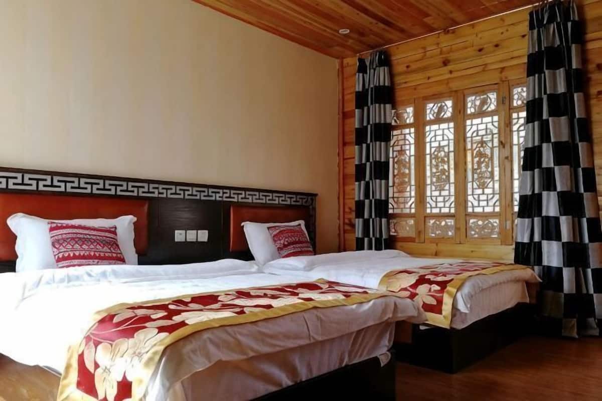 Cama de casal com cabeceira estampada, duas almofadas e colcha vermelha e branca.