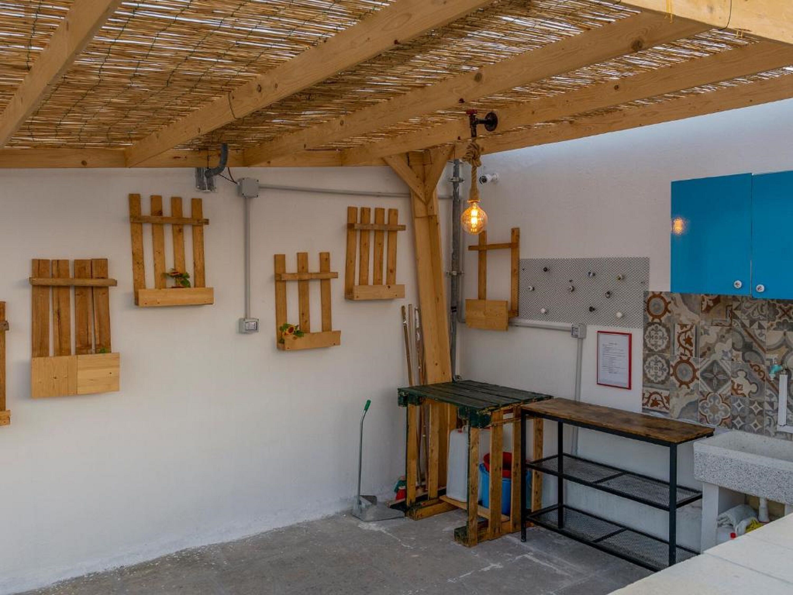 Cozinha rústica com vigas de madeira, mesa de madeira e luminária pendente.