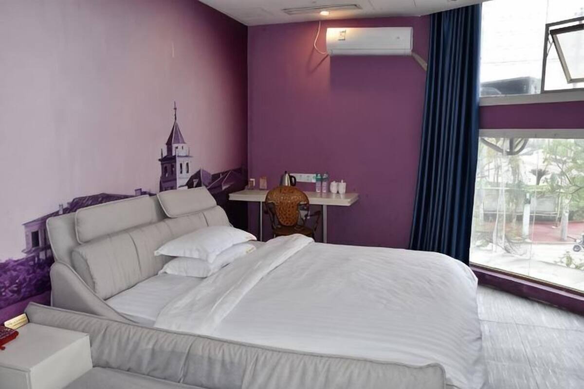 Quarto com cama, escrivaninha e janela.