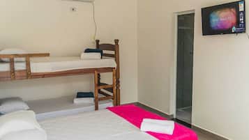 Quarto com beliches, uma cama de solteiro, televisão e chuveiro.