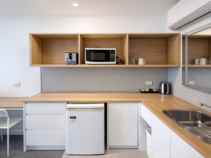 Uma cozinha moderna com micro-ondas, cafeteira e mini geladeira.