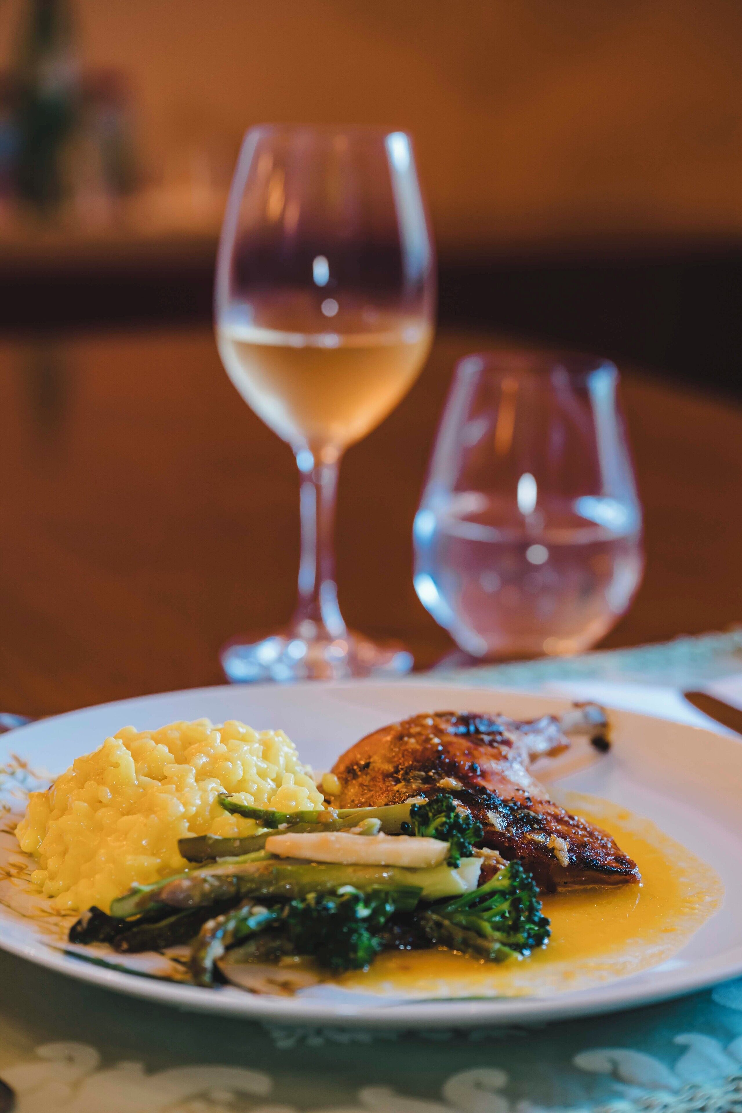 Prato de comida com um copo de vinho branco e um copo de vinho tinto sobre uma mesa.