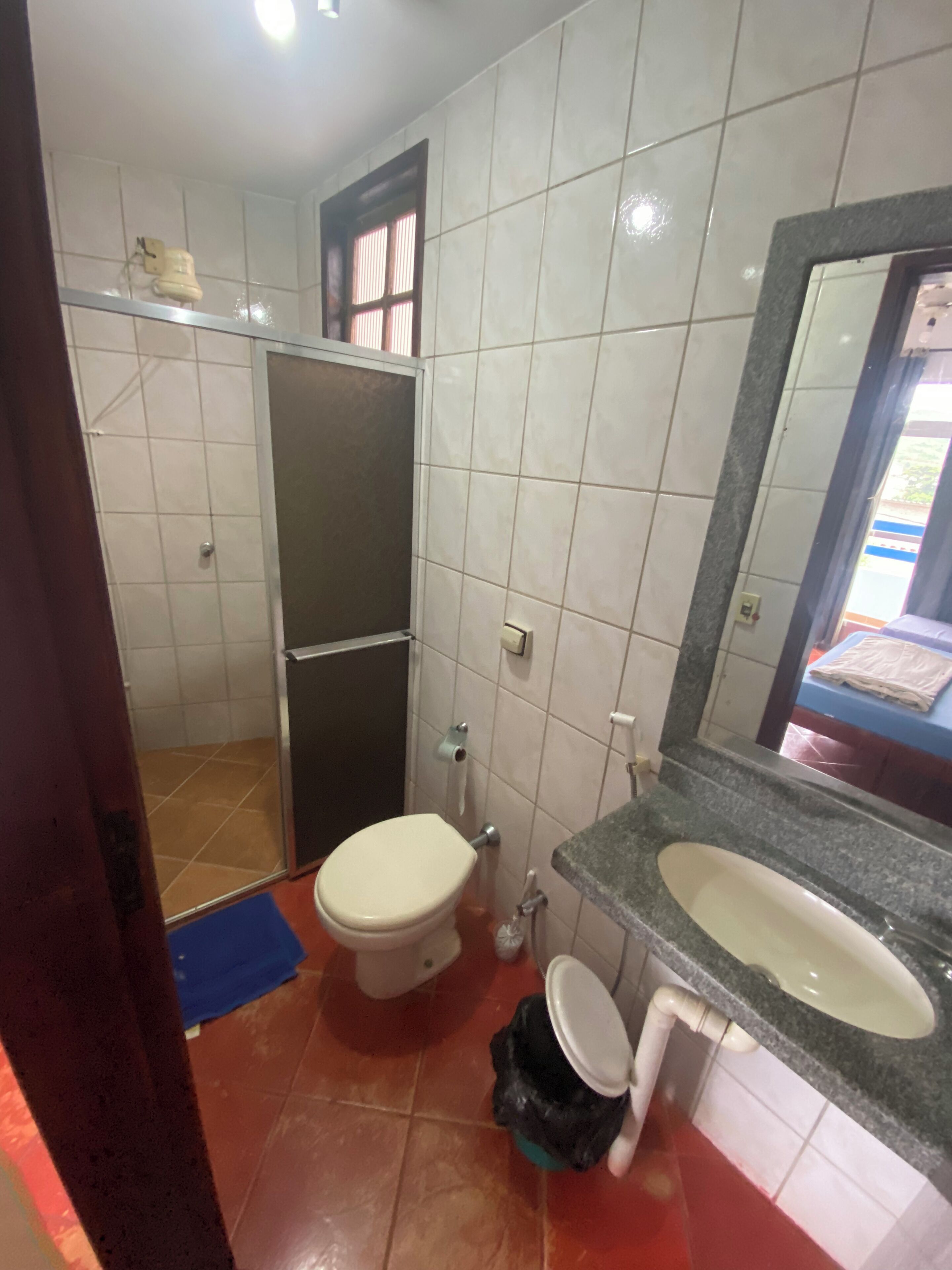 Casa de banho com sanita, lavatório e zona de duche.