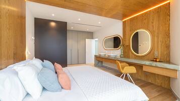 Quarto moderno com uma cama grande, uma penteadeira com espelhos e teto de madeira.