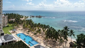 Um resort com piscina, praia e vista para o oceano.