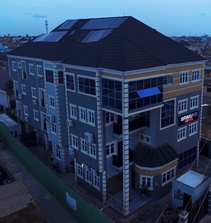 Um hotel com vários andares, teto plano, amplas janelas e painéis solares.