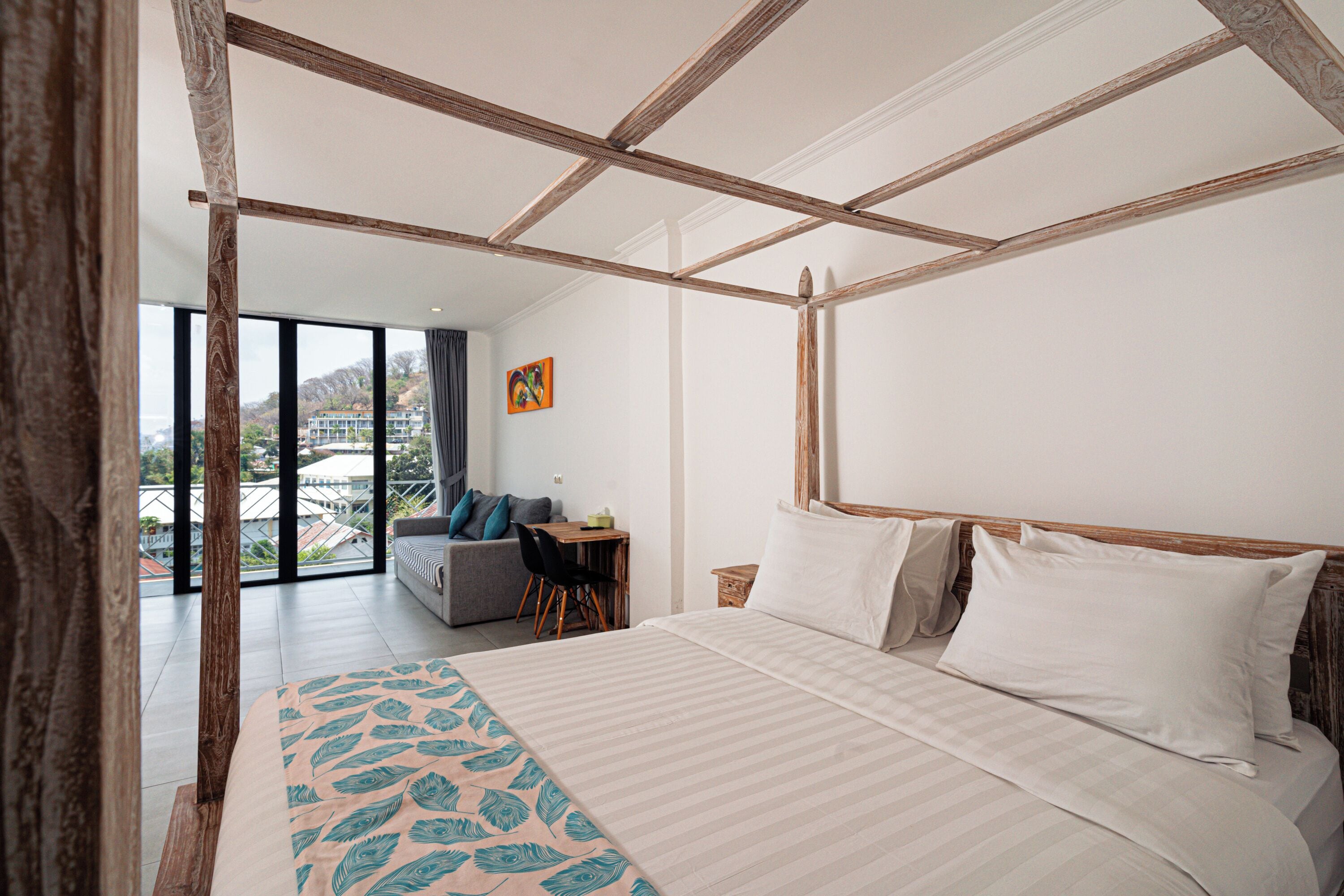 Um quarto espaçoso com uma cama grande, teto de madeira e vista para o exterior.