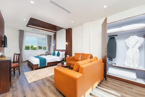 Quarto de hotel com cama, sofá, escrivaninha e closet espaçoso.