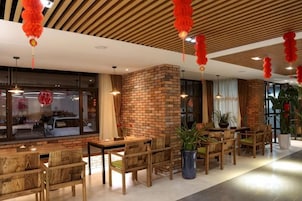 Decoração moderna com paredes de tijolo, móveis de madeira e enfeites vermelhos pendurados.
