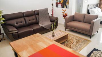 Uma sala de estar moderna com um sofá de couro marrom, uma mesa de centro de madeira e um tapete estampado.
