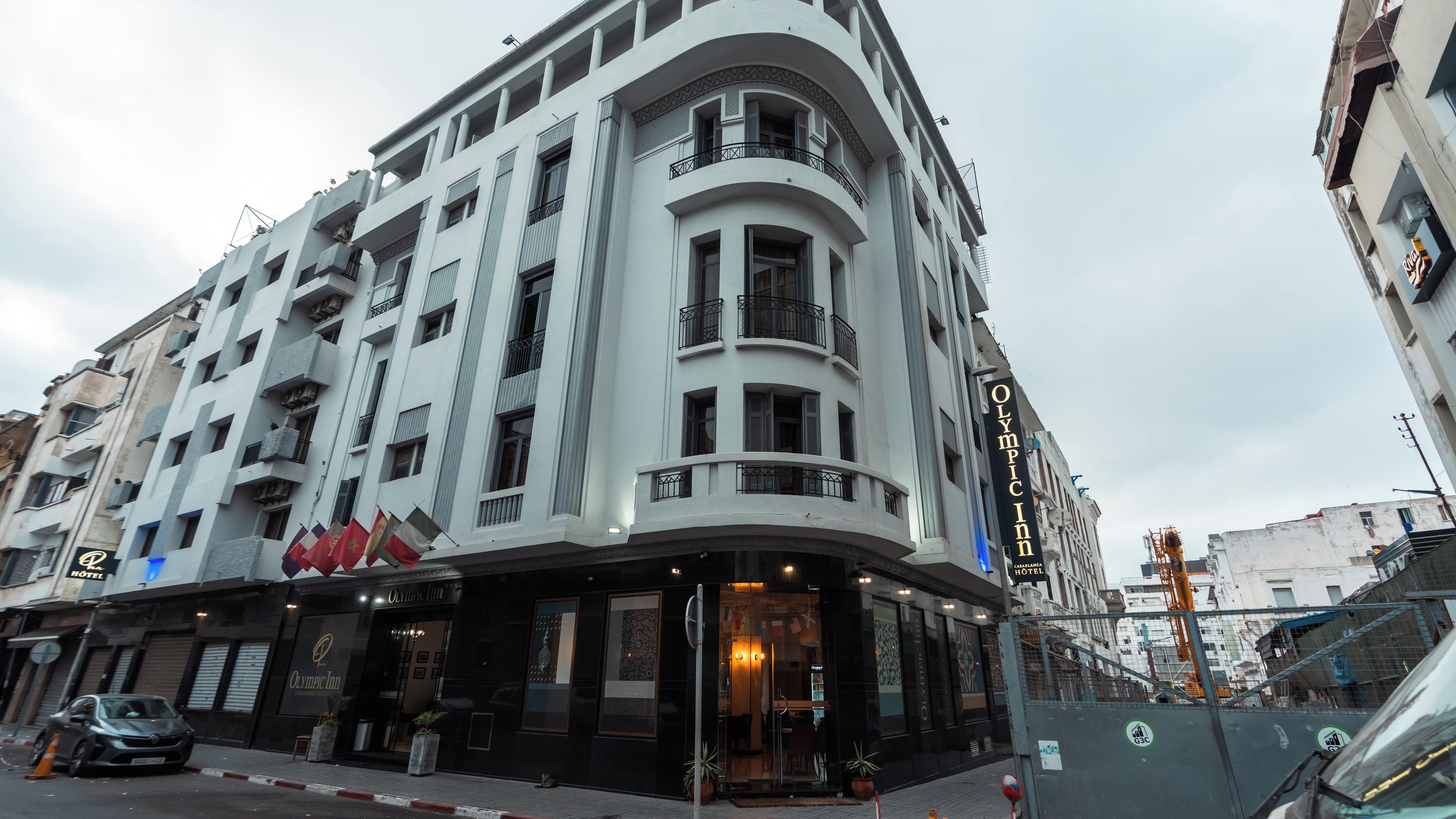 Hotel com fachada curva, várias varandas e entrada destacada.