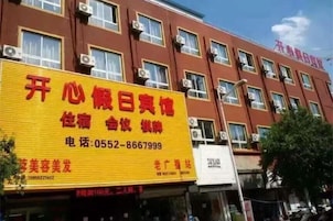 Hotel com placa amarela exibindo informações de contato e serviços.