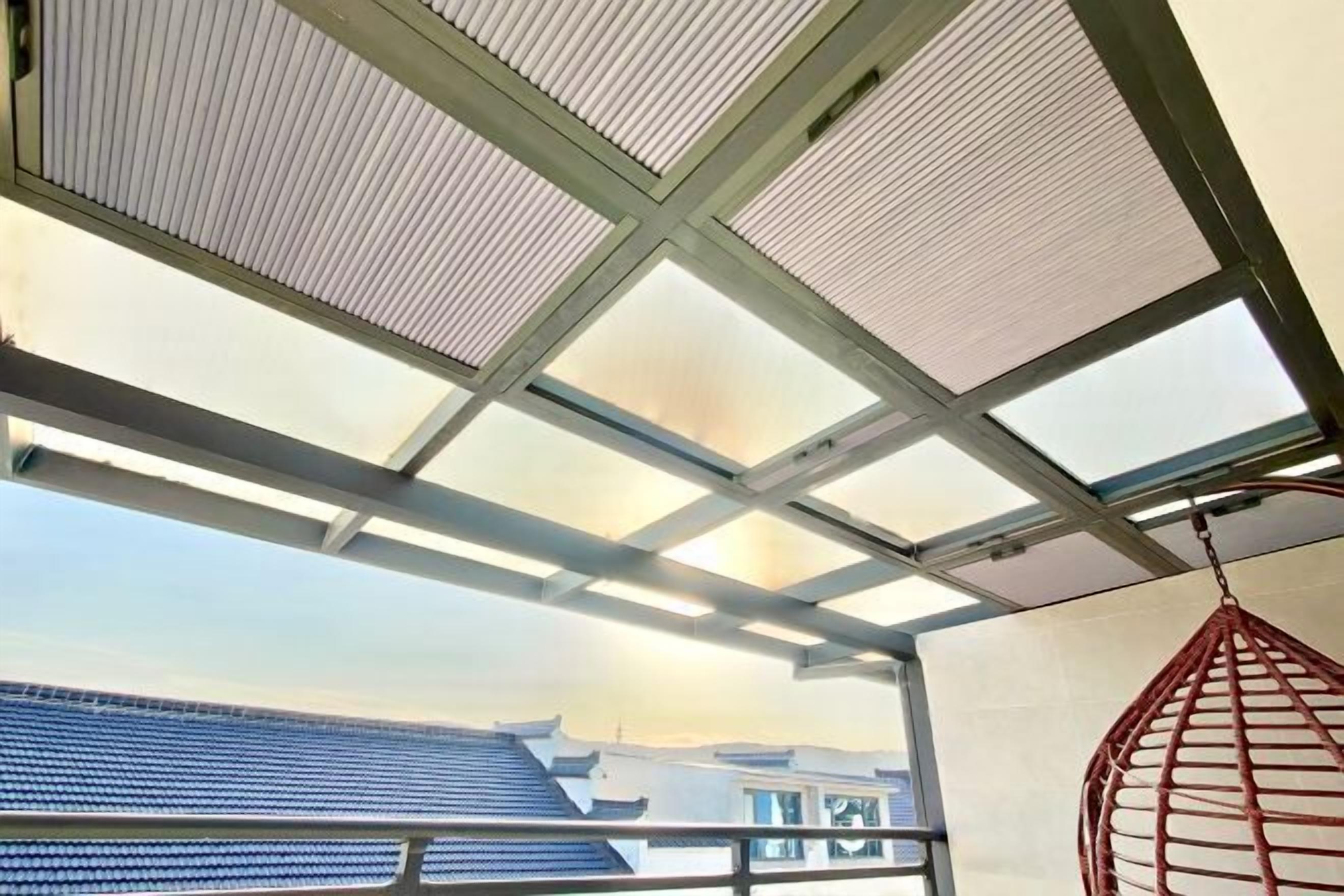 Quarto com claraboia, cadeira suspensa e vista para edifícios tradicionais.