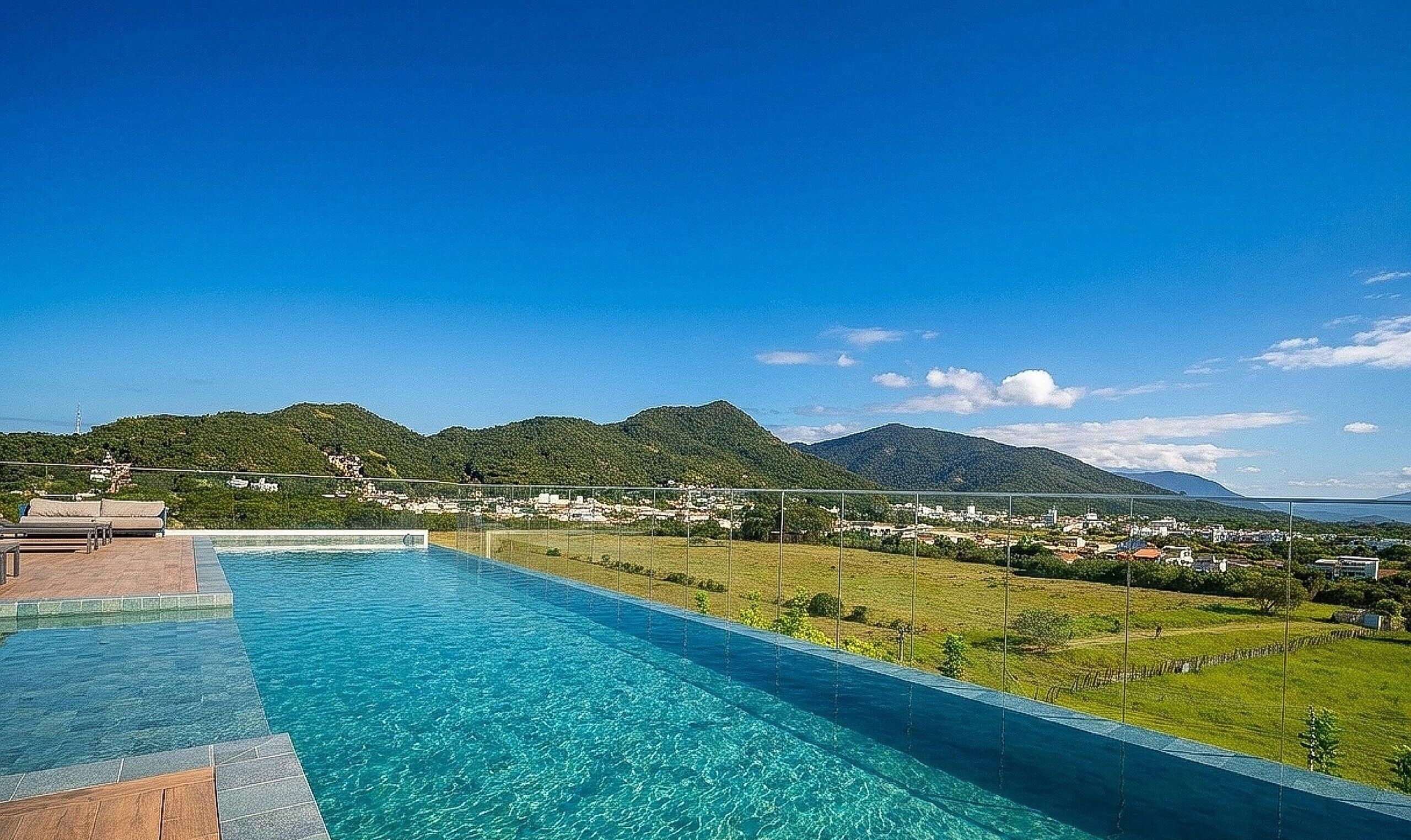 Piscina com vista para uma cidade e montanhas.