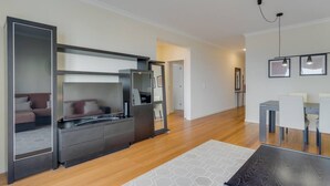 Uma sala de estar moderna com um sofá, uma mesa de centro e uma área de refeições com cadeiras.