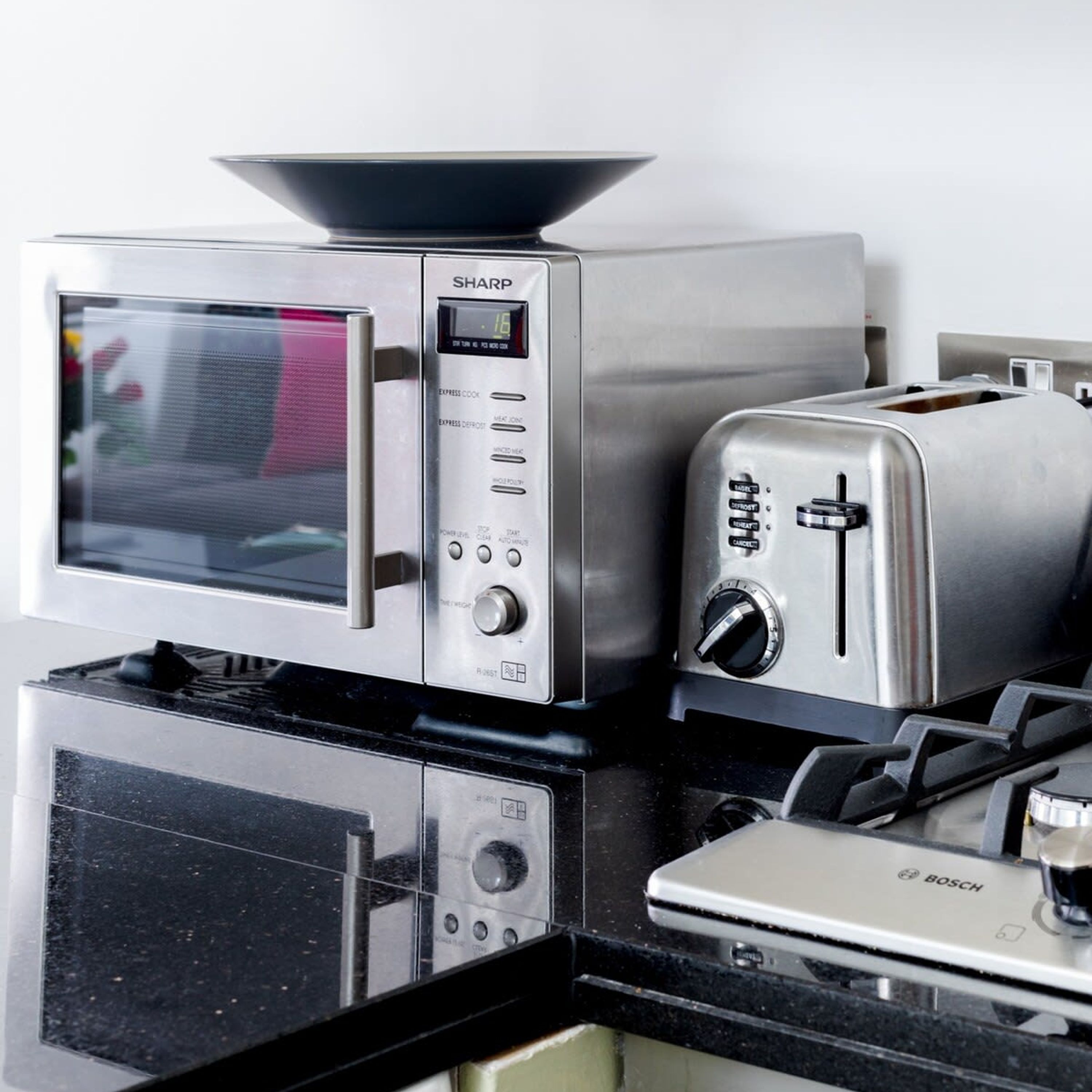 Cozinha equipada com micro-ondas, torradeira e eletrodomésticos Bosch.