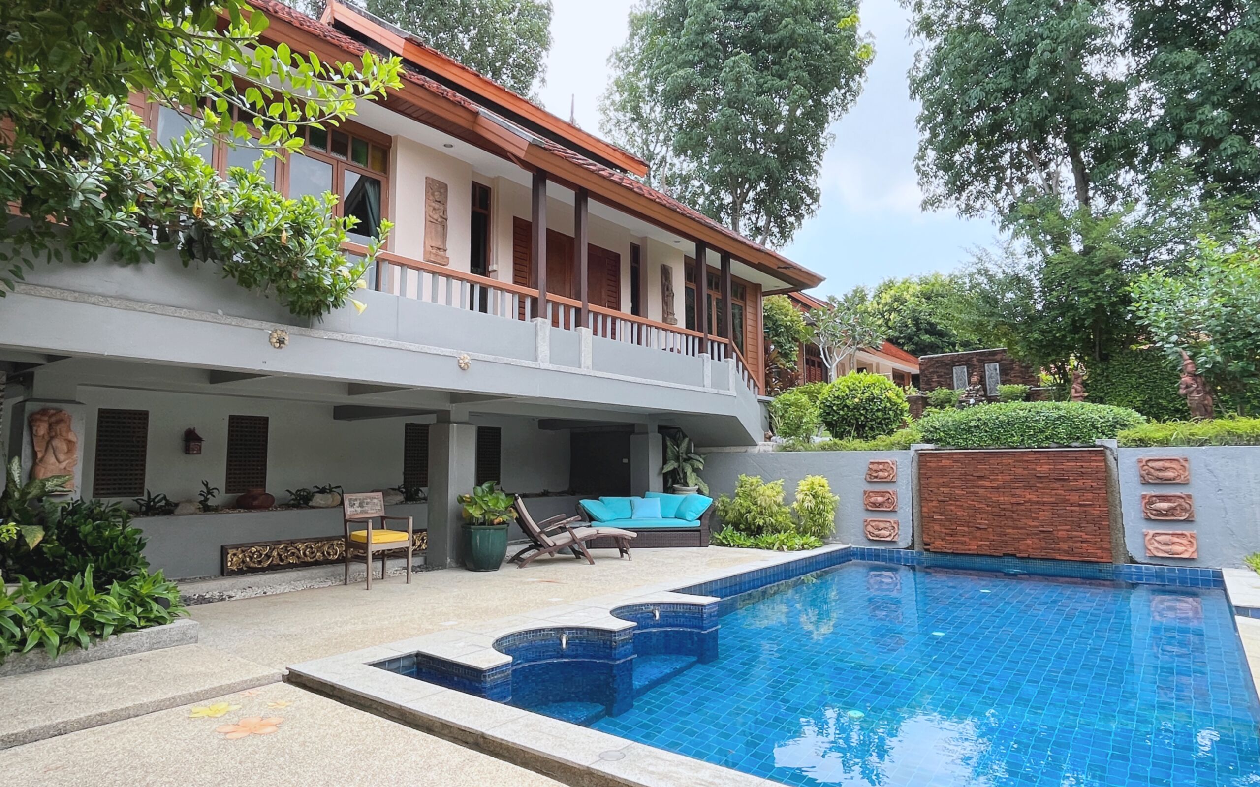 Uma casa de dois andares com piscina, varanda e jardim.