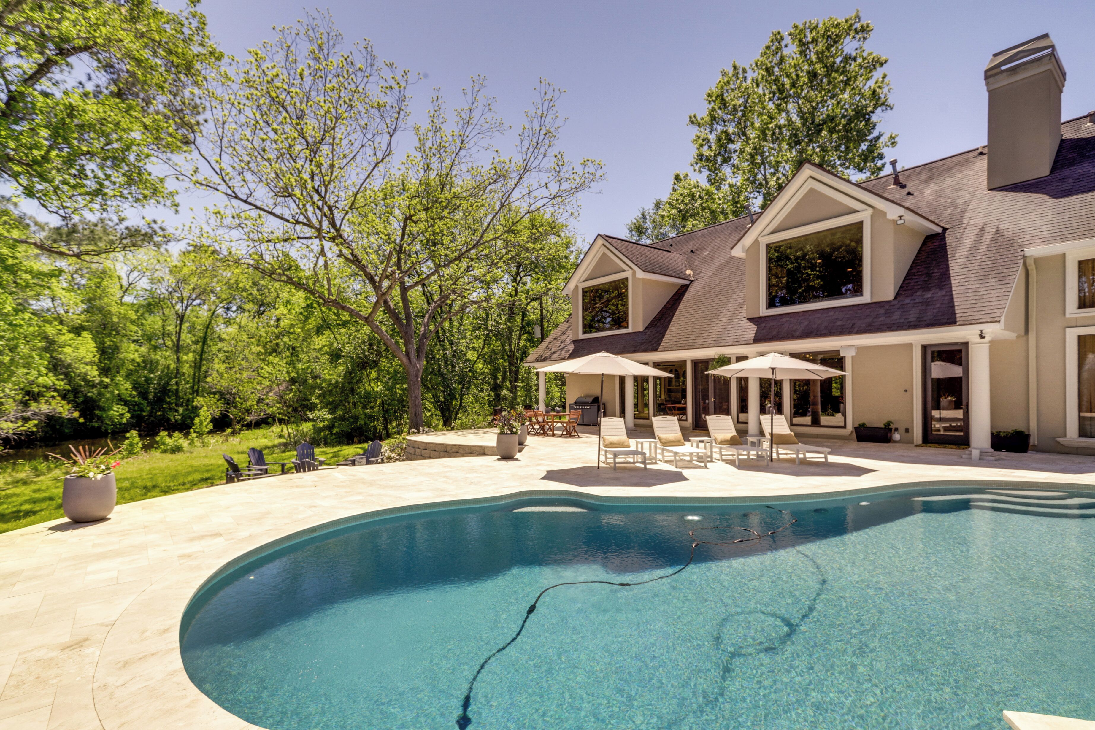 Uma casa moderna com piscina, área de estar ao ar livre e jardim bem cuidado.