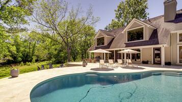 Uma casa moderna com piscina, área de estar ao ar livre e jardim bem cuidado.