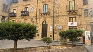 Um edifício com fachada de pedra, várias varandas e uma placa com a inscrição 'La casa del vino'.