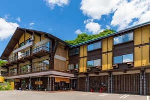 Um hotel de vários andares com design arquitetônico moderno, com varandas e grandes janelas.