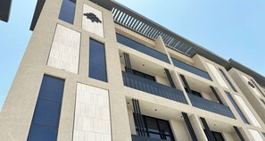 Um edifício de vários andares com design arquitetônico moderno, com grandes janelas e varandas.