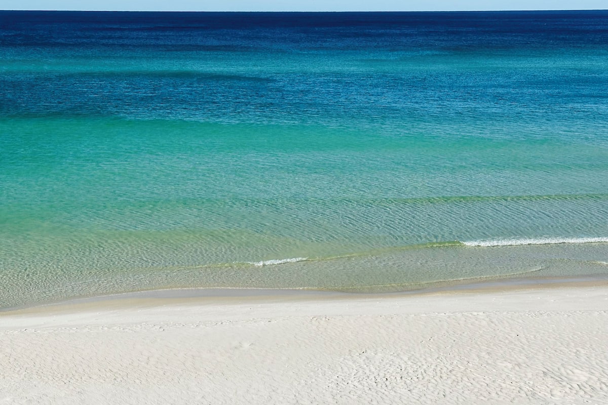 Praia particular, areia branca, espreguiçadeiras, guarda-sóis