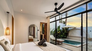 Quarto moderno com uma cama grande, um ventilador de teto e vista para uma piscina e área externa.