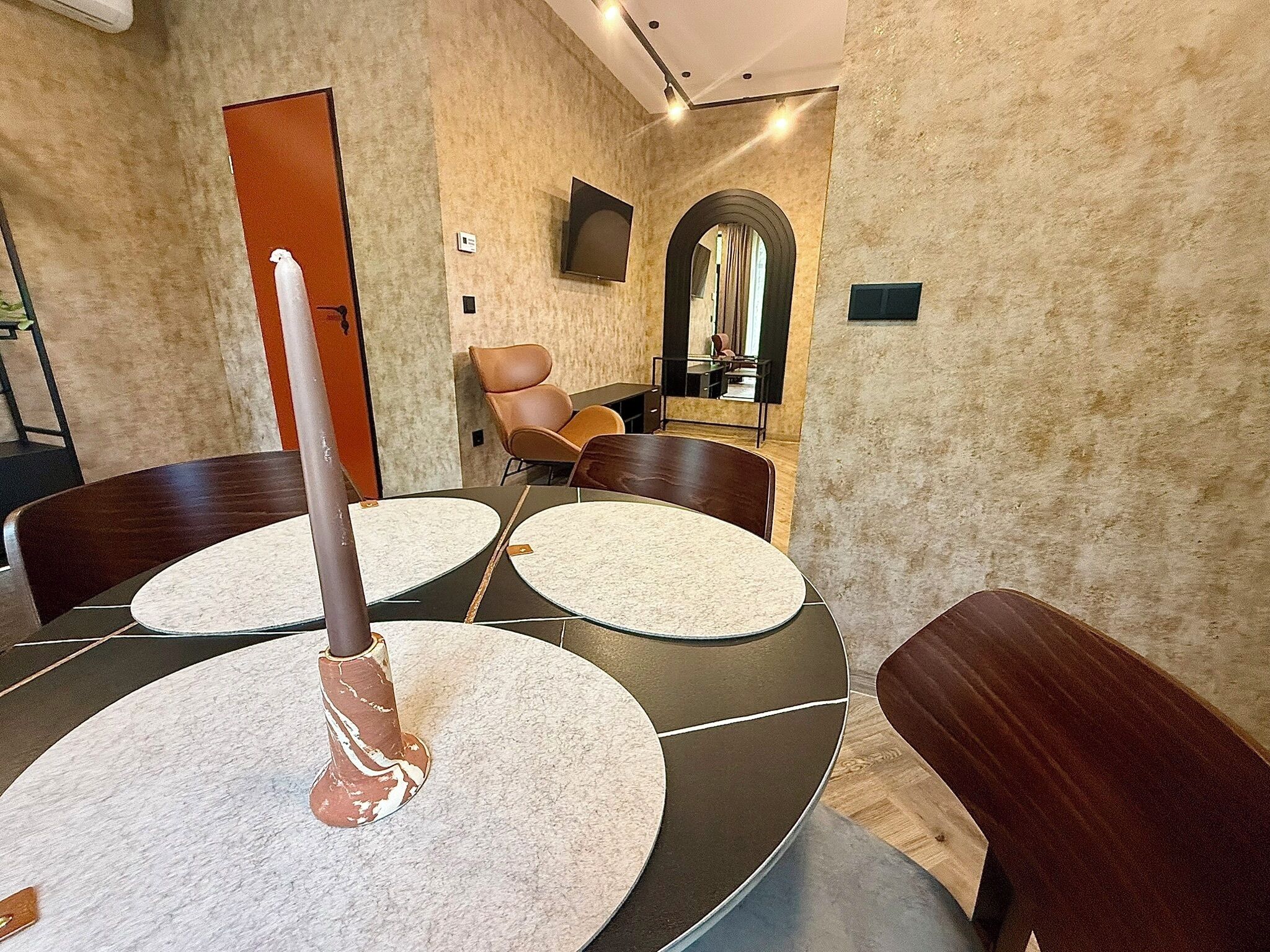 Uma área de jantar moderna com uma mesa redonda, cadeiras e um arranjo de velas.
