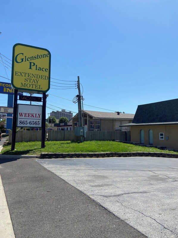 Placa de motel com o nome 'Glenstone Place' e um número de contato.