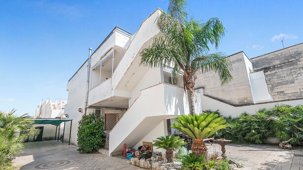 Um edifício moderno com design arquitetônico singular, apresentando uma escadaria que leva a um andar superior.