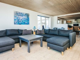 Uma sala de estar moderna com um sofá seccional, uma mesa de centro e um quadro na parede.