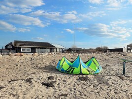 Uma praia com uma tenda e um edifício com telhado de metal.