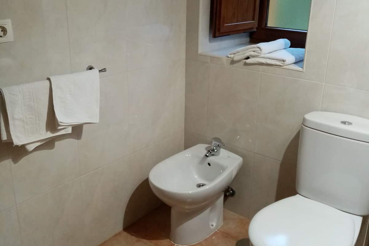 Um banheiro pequeno com vaso sanitário, bidê e pia.