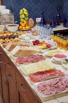 Buffet com diversos alimentos, incluindo pão, carnes e acompanhamentos.