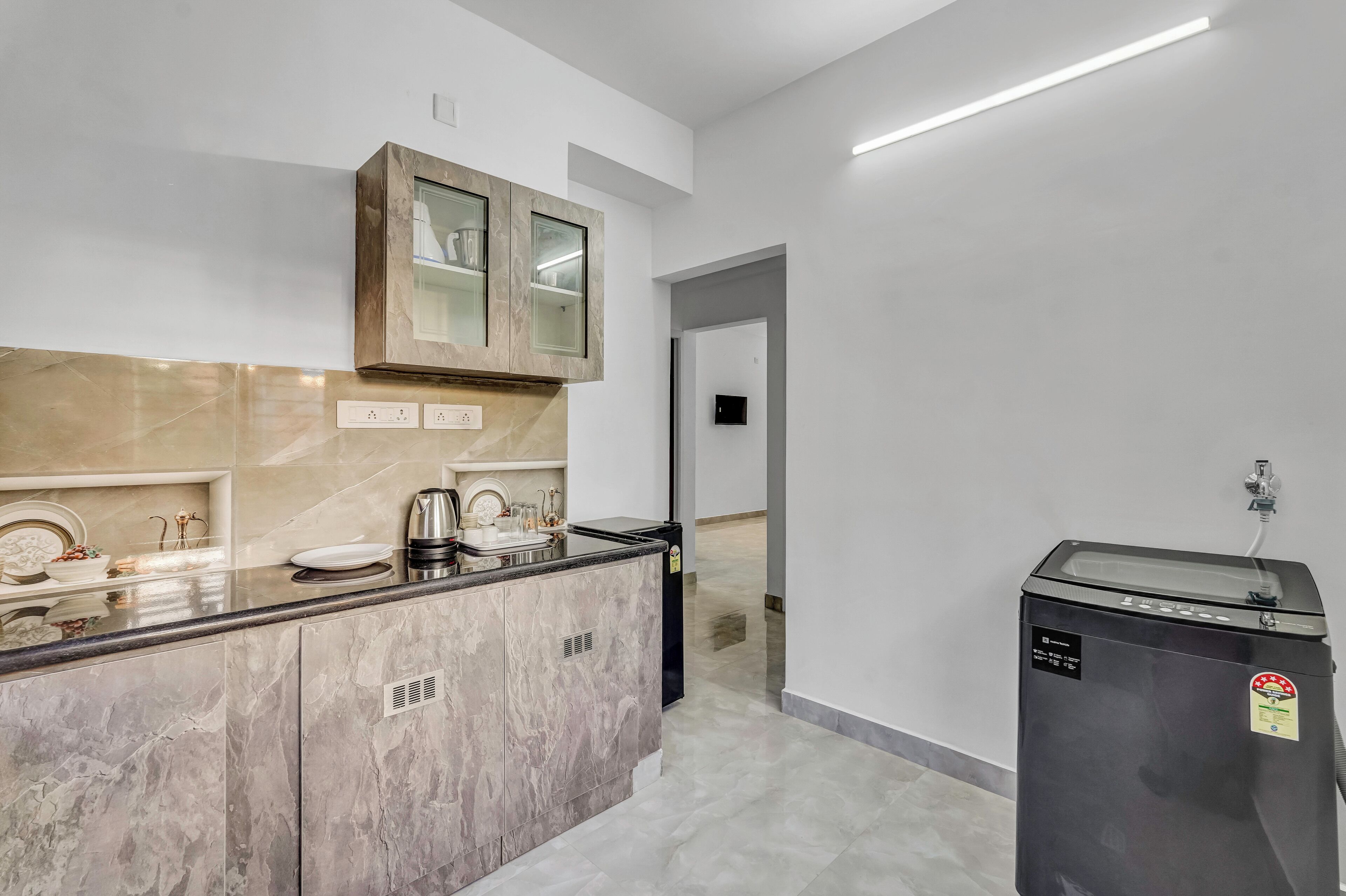 Cozinha moderna com bancadas de mármore, pia embutida e máquina de café.