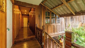 Escada de madeira que leva a uma área externa coberta, com uma janela e uma porta.