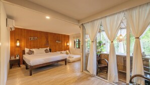 Quarto com cabeceira de madeira, cama grande, mesa de cabeceira e janela com cortinas finas.