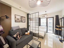 Uma sala de estar moderna com sofá, mesa de centro e cama com vista para a cidade.